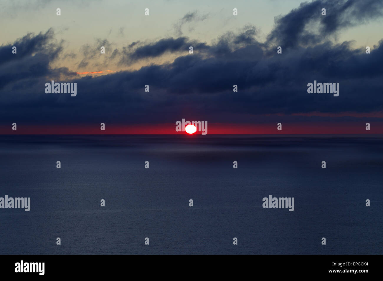 red sun at dark blue sea Stock Photo - Alamy