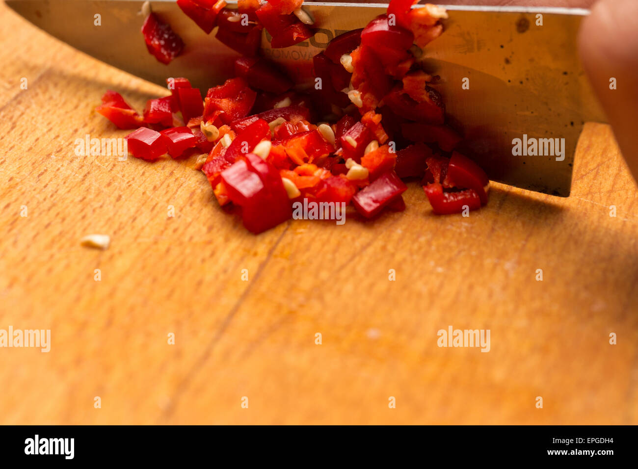 A knife being used to chop a red chilli pepper Stock Photo - Alamy
