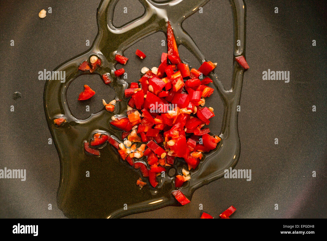 A chopped red chilli pepper in a frying pan Stock Photo - Alamy