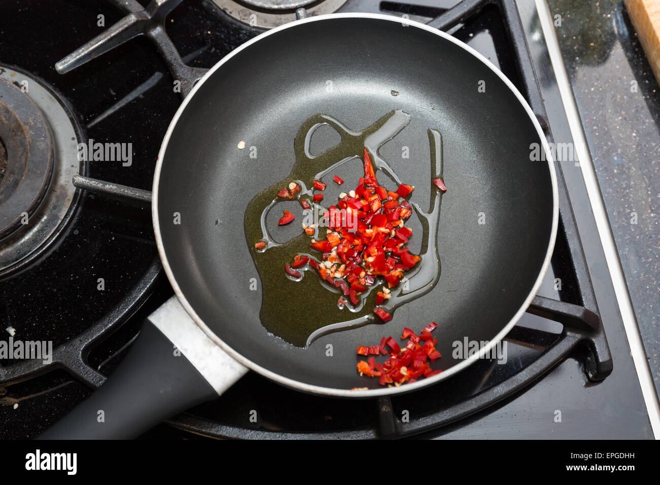 A chopped red chilli pepper in a frying pan Stock Photo - Alamy