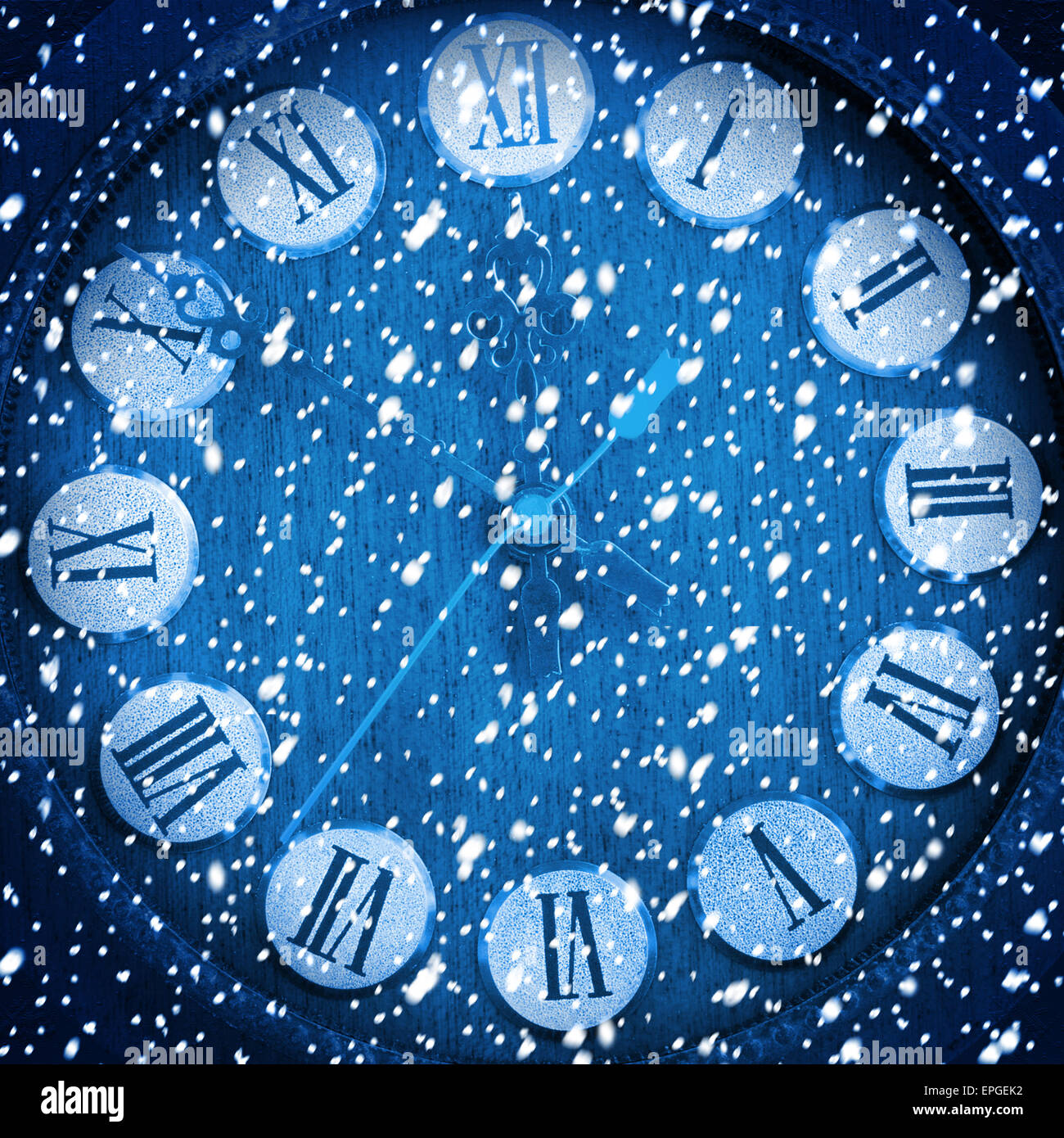 Snow-covered clock on abstract blue background Stock Photo - Alamy