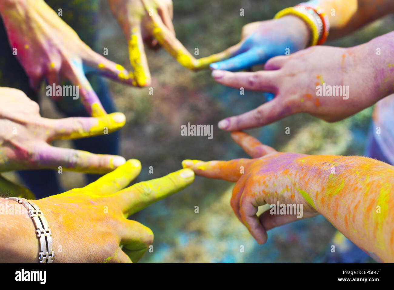 Friends putting their hands together in a sign of unity and teamwork ...