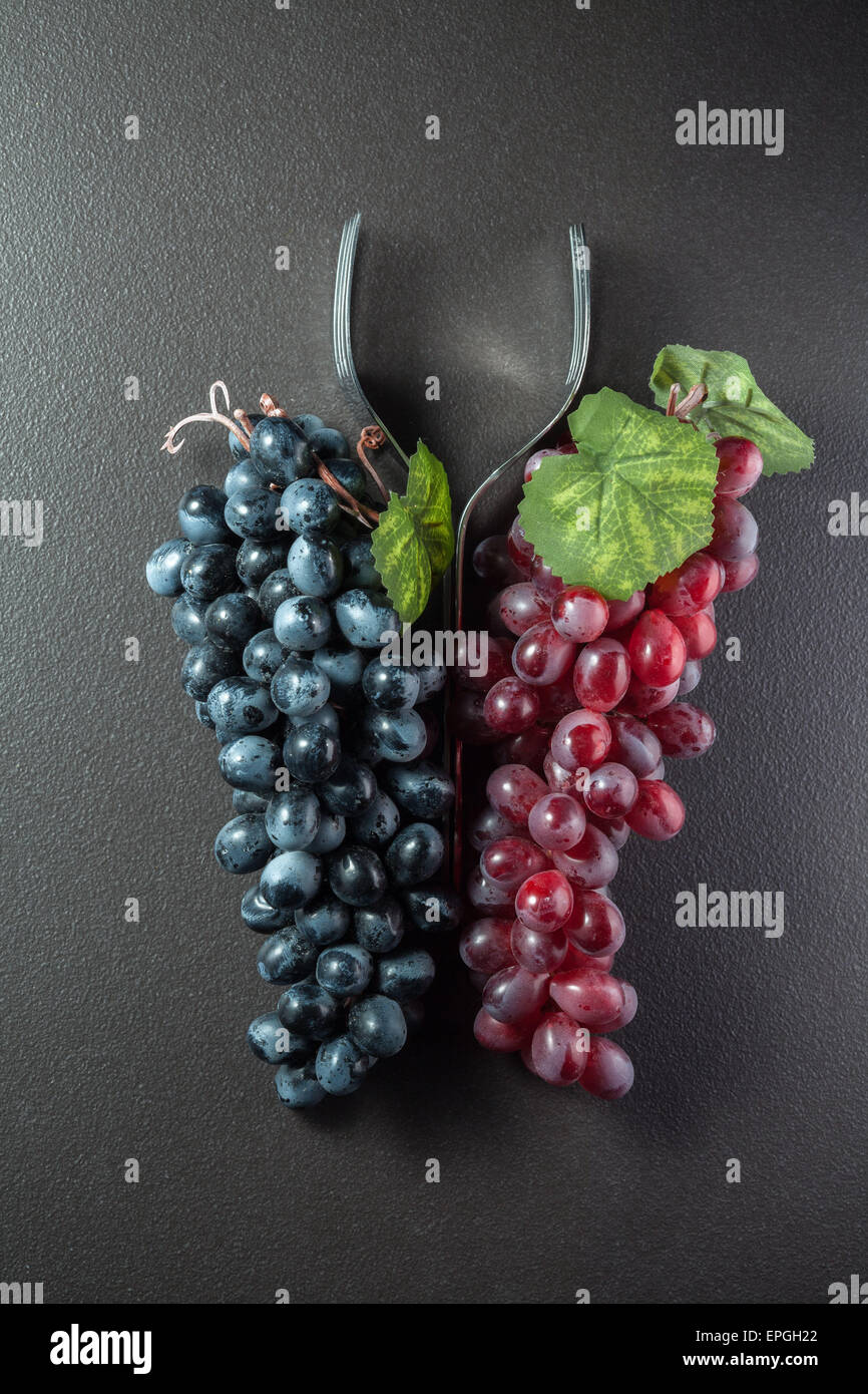 Wine glass made of forks and grape on black Stock Photo - Alamy