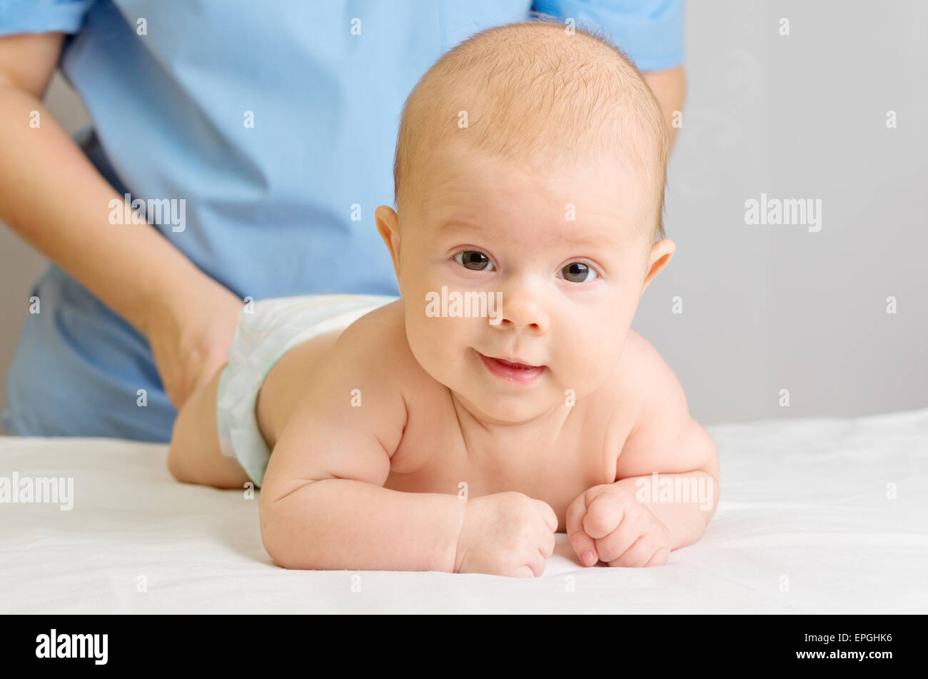 Doctor with little baby on grey Stock Photo - Alamy