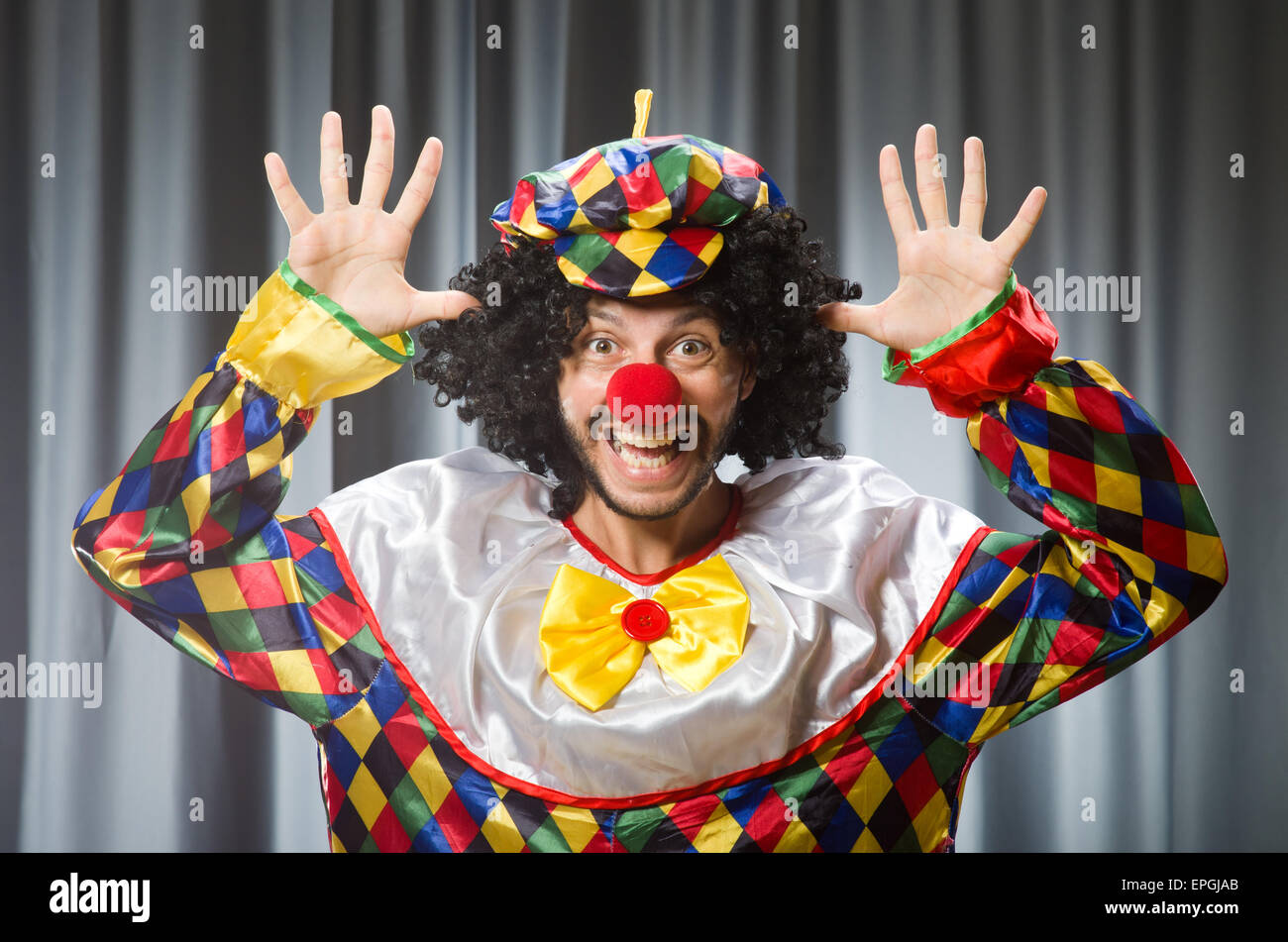 Funny clown in humorous concept against curtain Stock Photo - Alamy