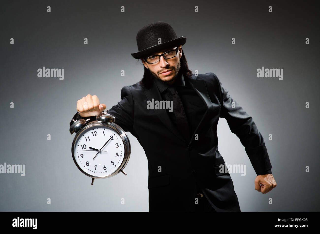 Man with clock wearing vintage hat Stock Photo - Alamy