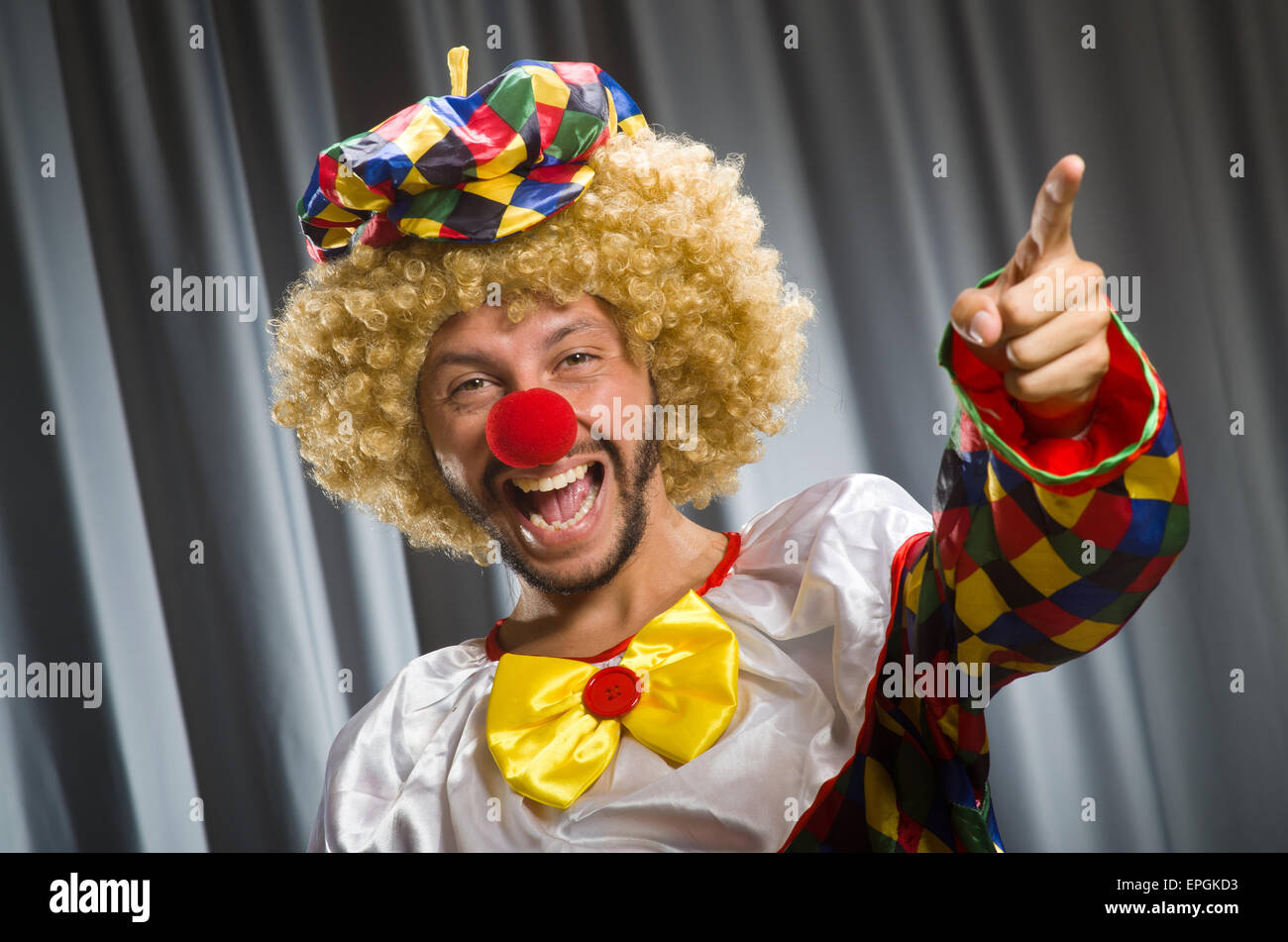 Funny clown in humorous concept against curtain Stock Photo - Alamy