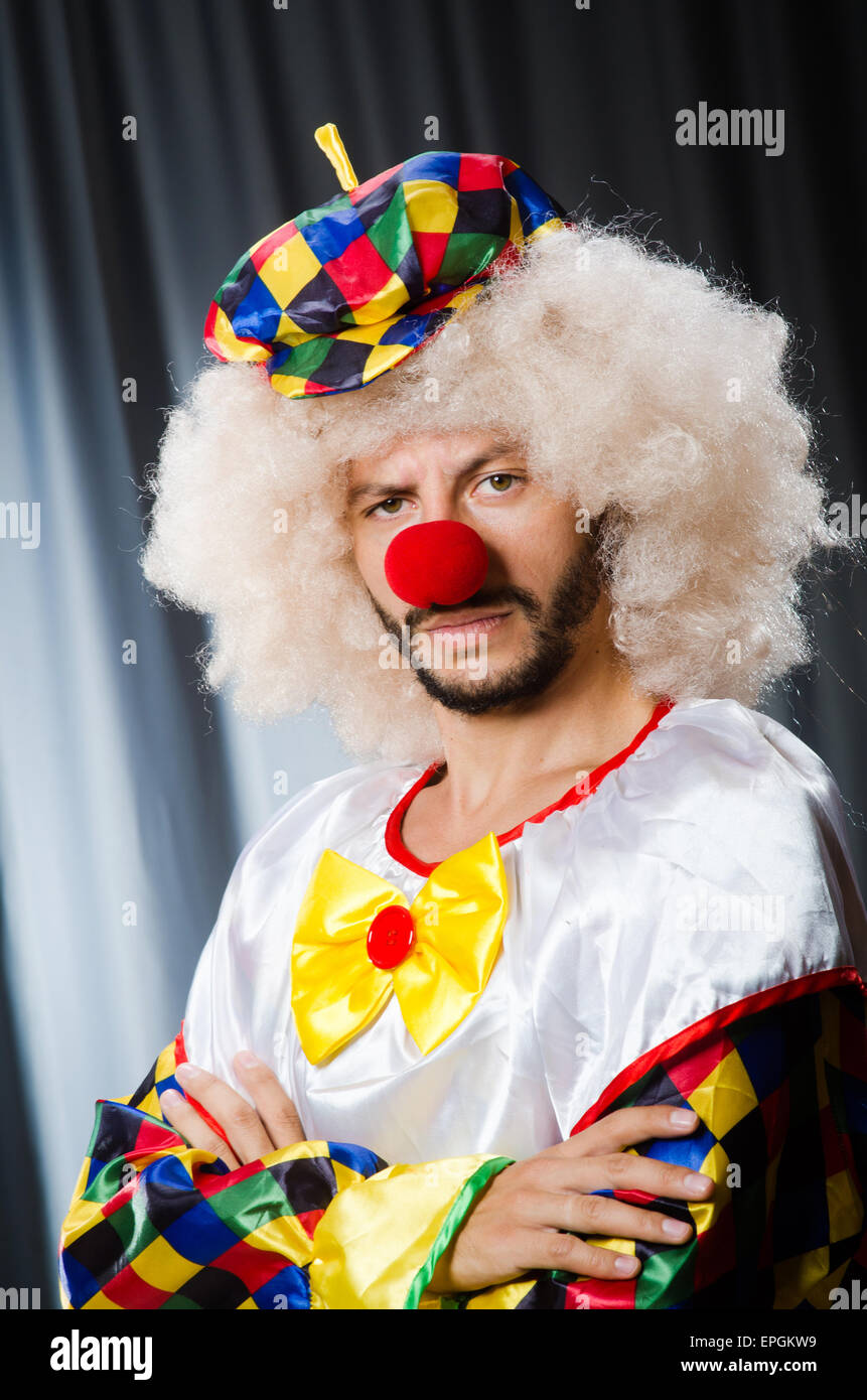 Funny clown in humorous concept against curtain Stock Photo - Alamy