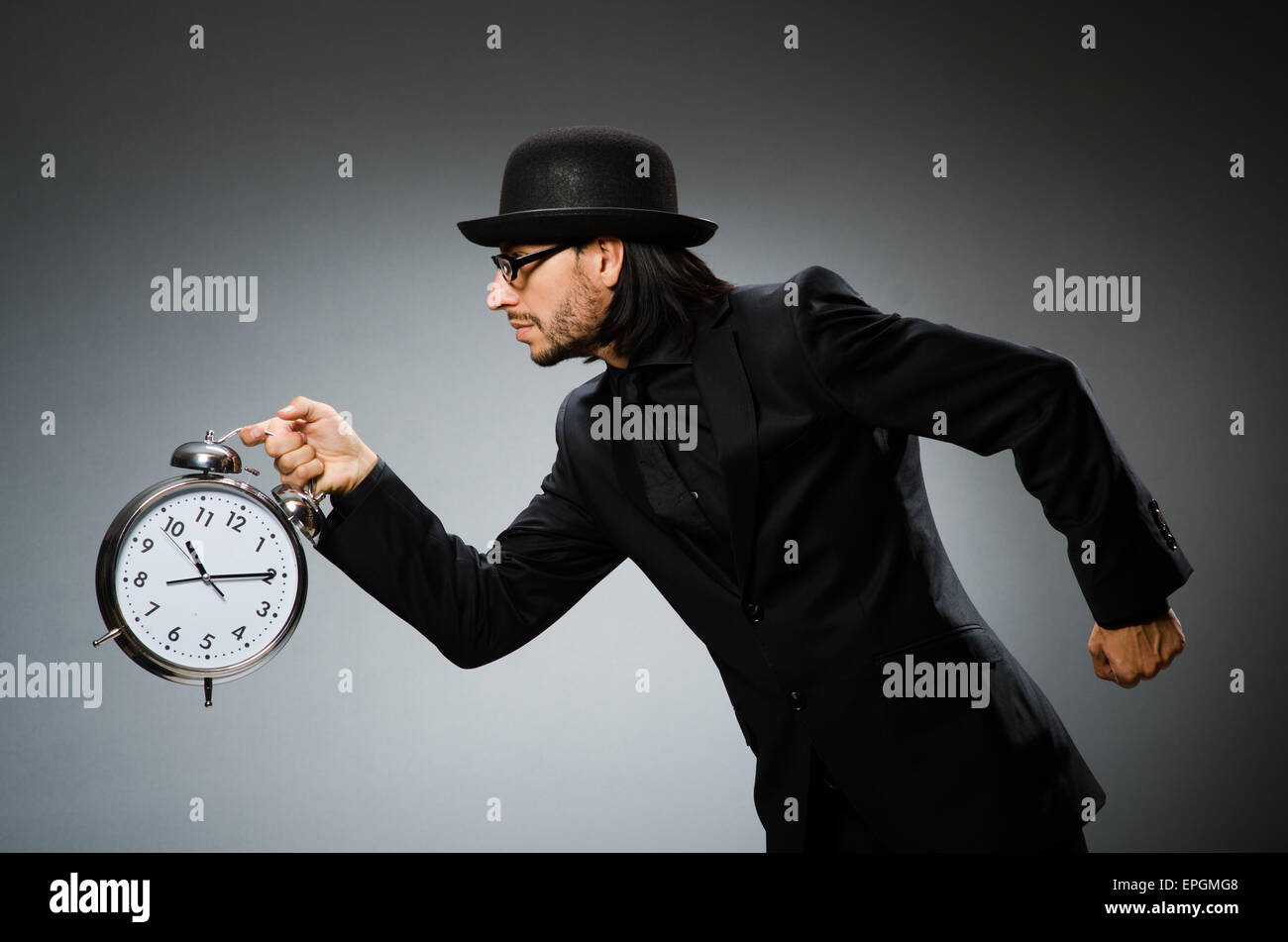 Man with clock wearing vintage hat Stock Photo - Alamy