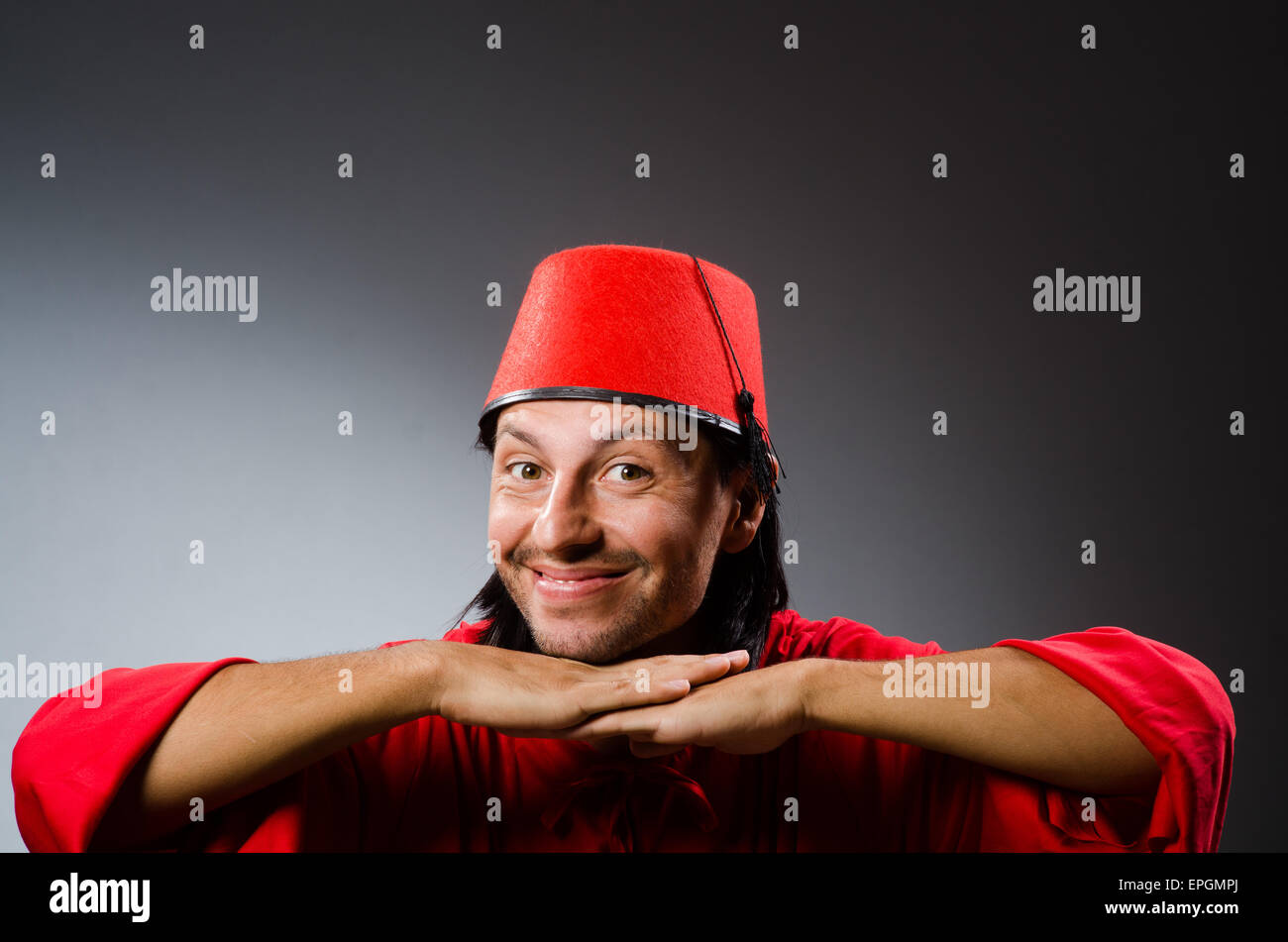 Funny man in red dress wearing fez hat Stock Photo - Alamy