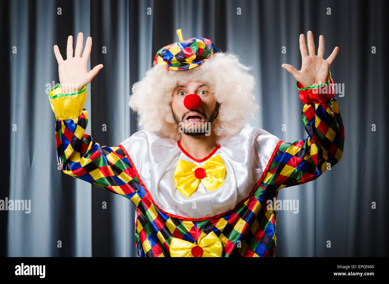 Funny clown in humorous concept against curtain Stock Photo - Alamy