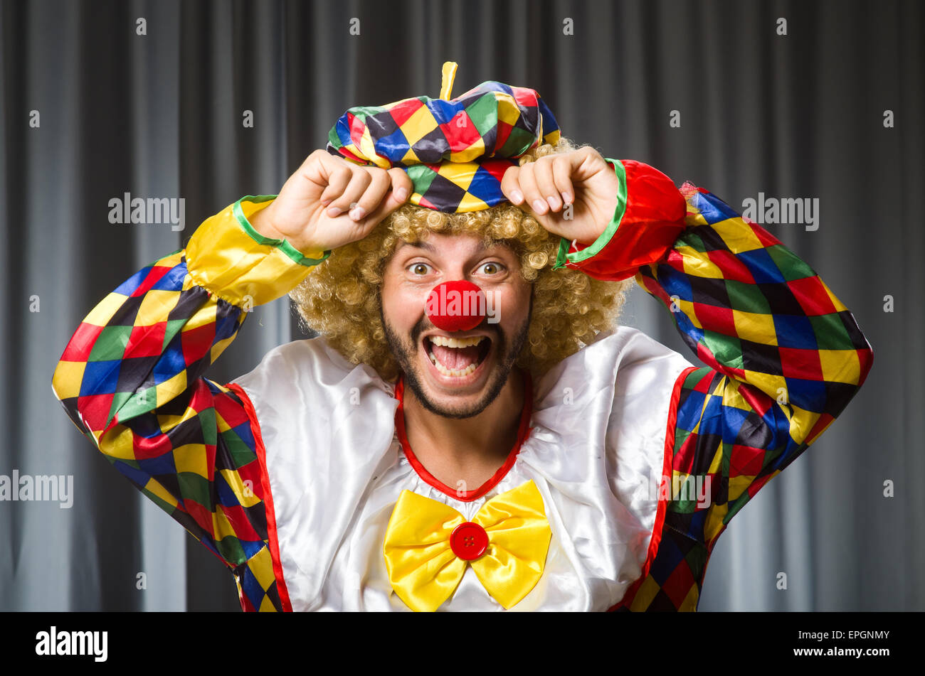 Funny clown in humorous concept against curtain Stock Photo - Alamy