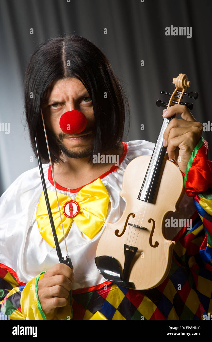 Funny clown plyaing violin against curtain Stock Photo - Alamy