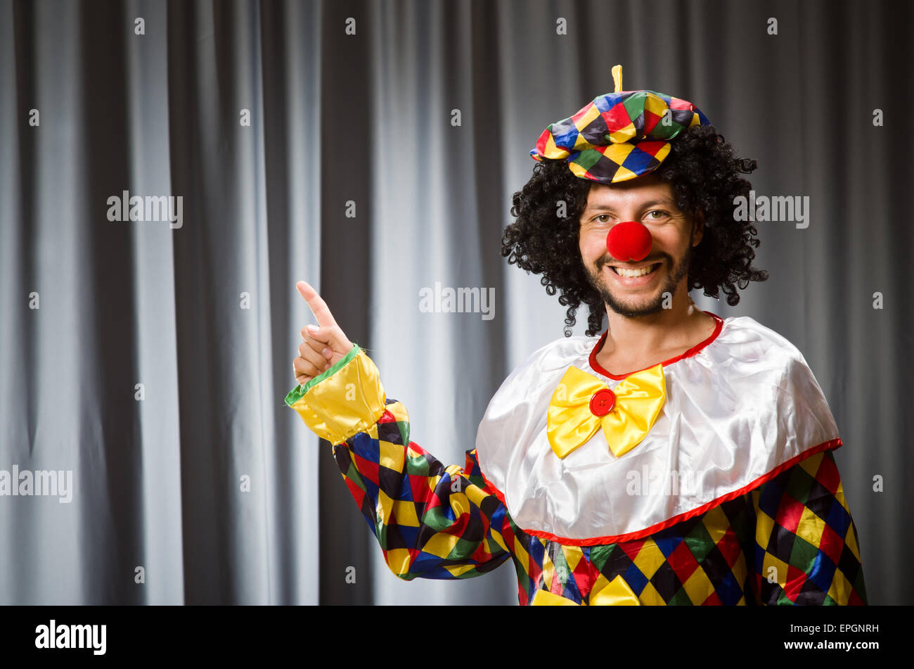 Funny clown in humorous concept against curtain Stock Photo - Alamy