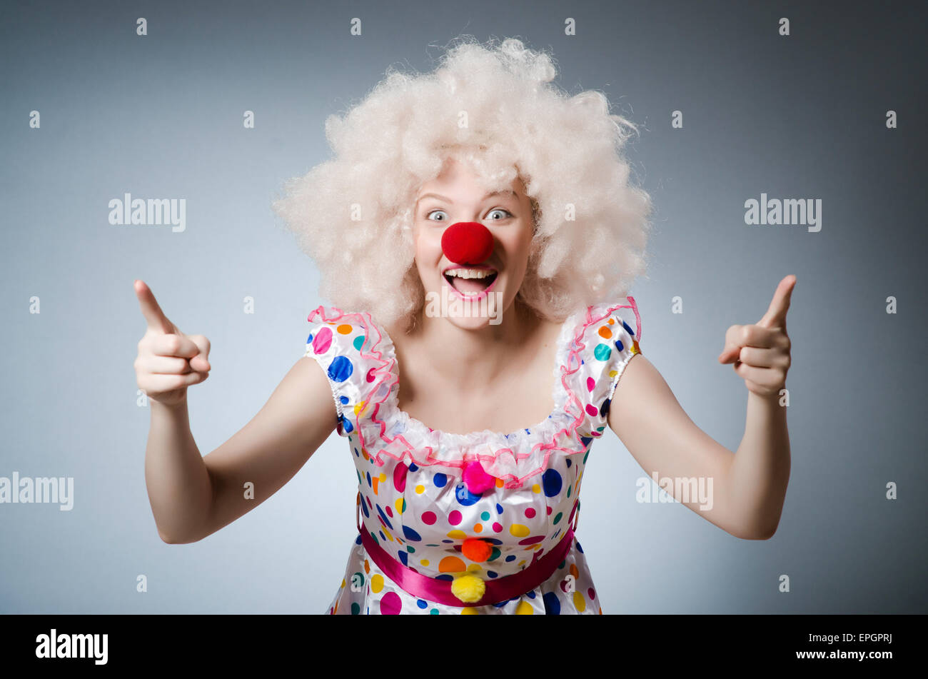 Clown with white wig against grey background Stock Photo - Alamy