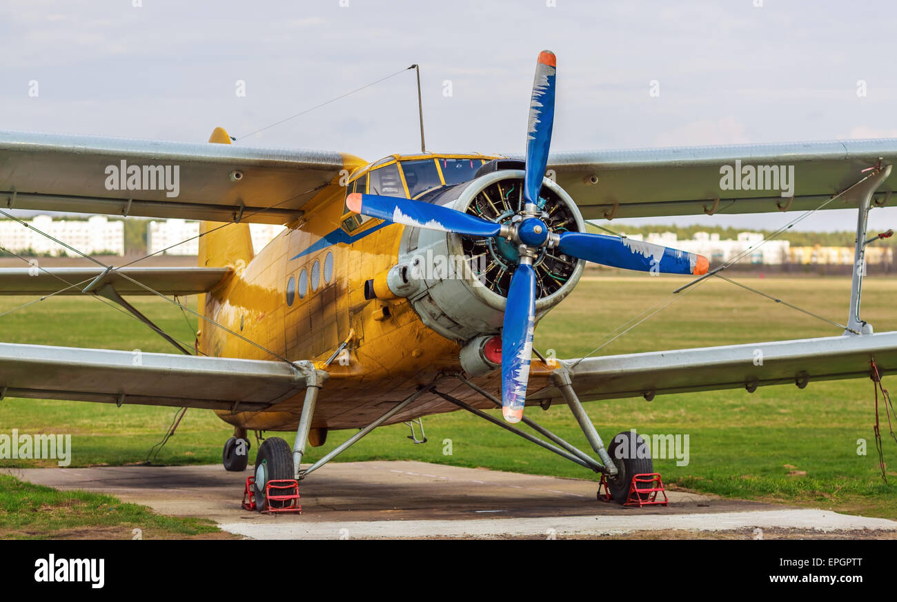 Old yellow vintage single-engined biplane with blue propeller. The ...