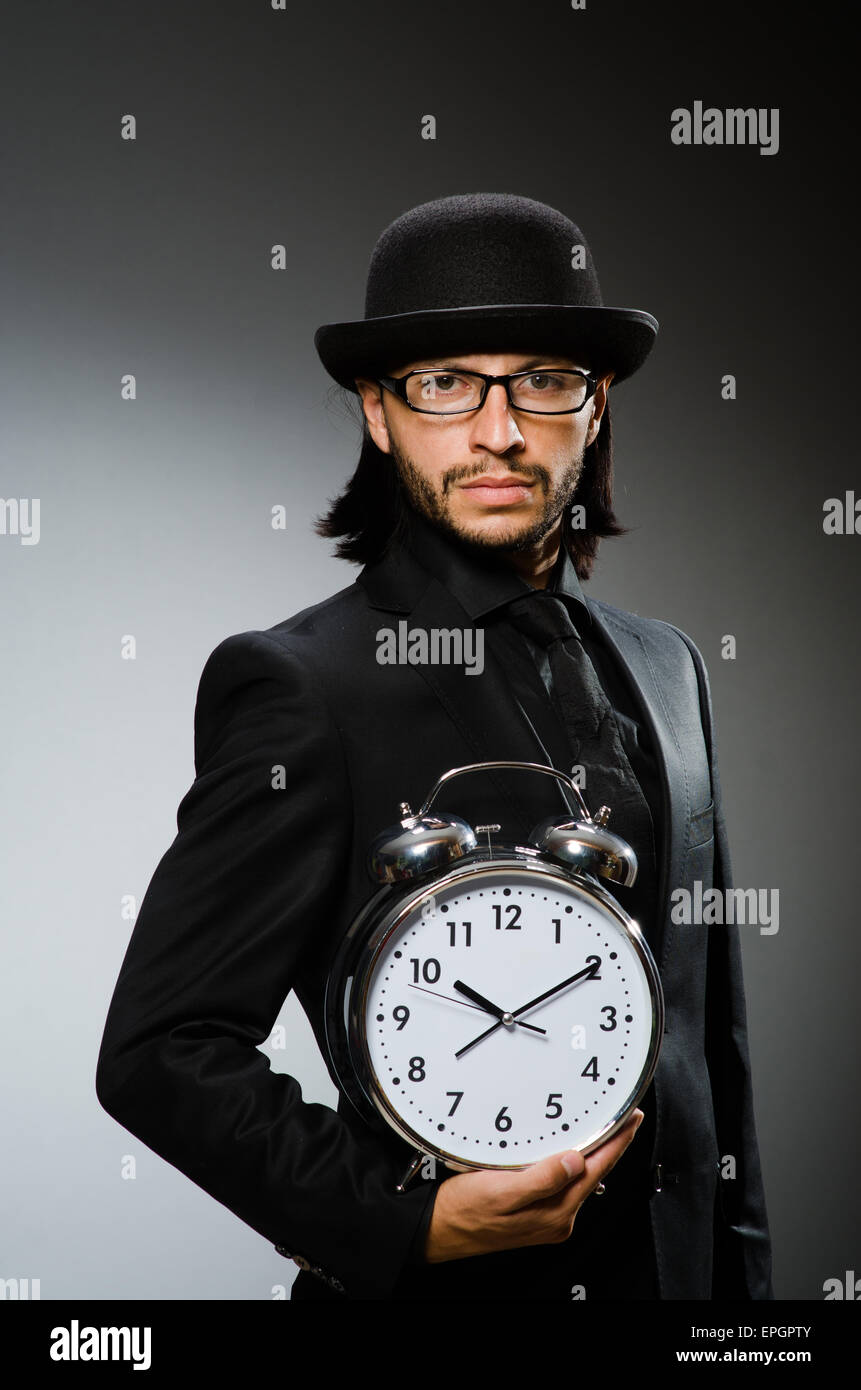 Man with clock wearing vintage hat Stock Photo - Alamy