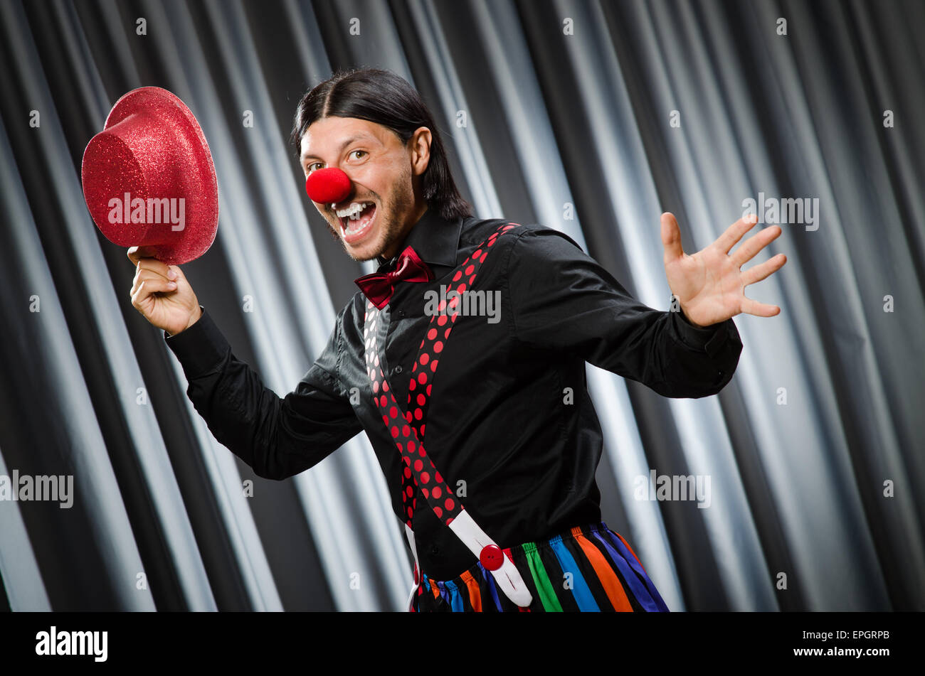 Funny clown in humorous concept against curtain Stock Photo - Alamy