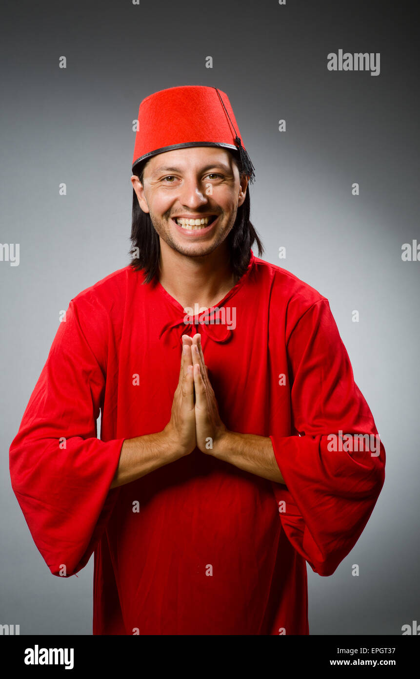 Man in red dress wearing fez hat Stock Photo - Alamy