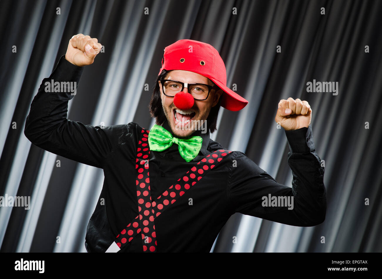 Funny clown in humorous concept against curtain Stock Photo - Alamy