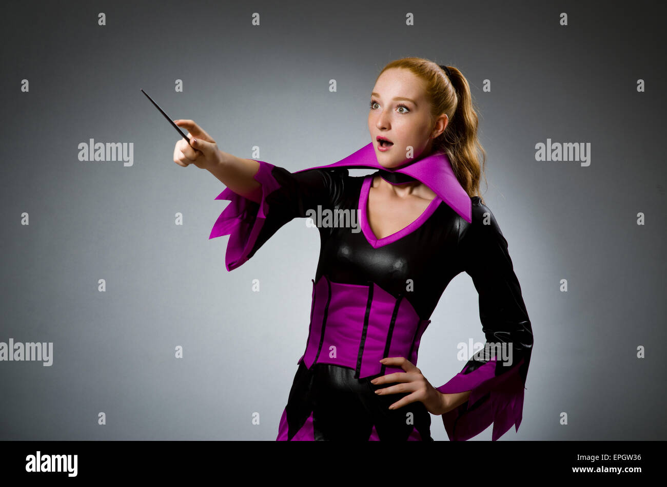 Female magician doing tricks on grey background Stock Photo - Alamy
