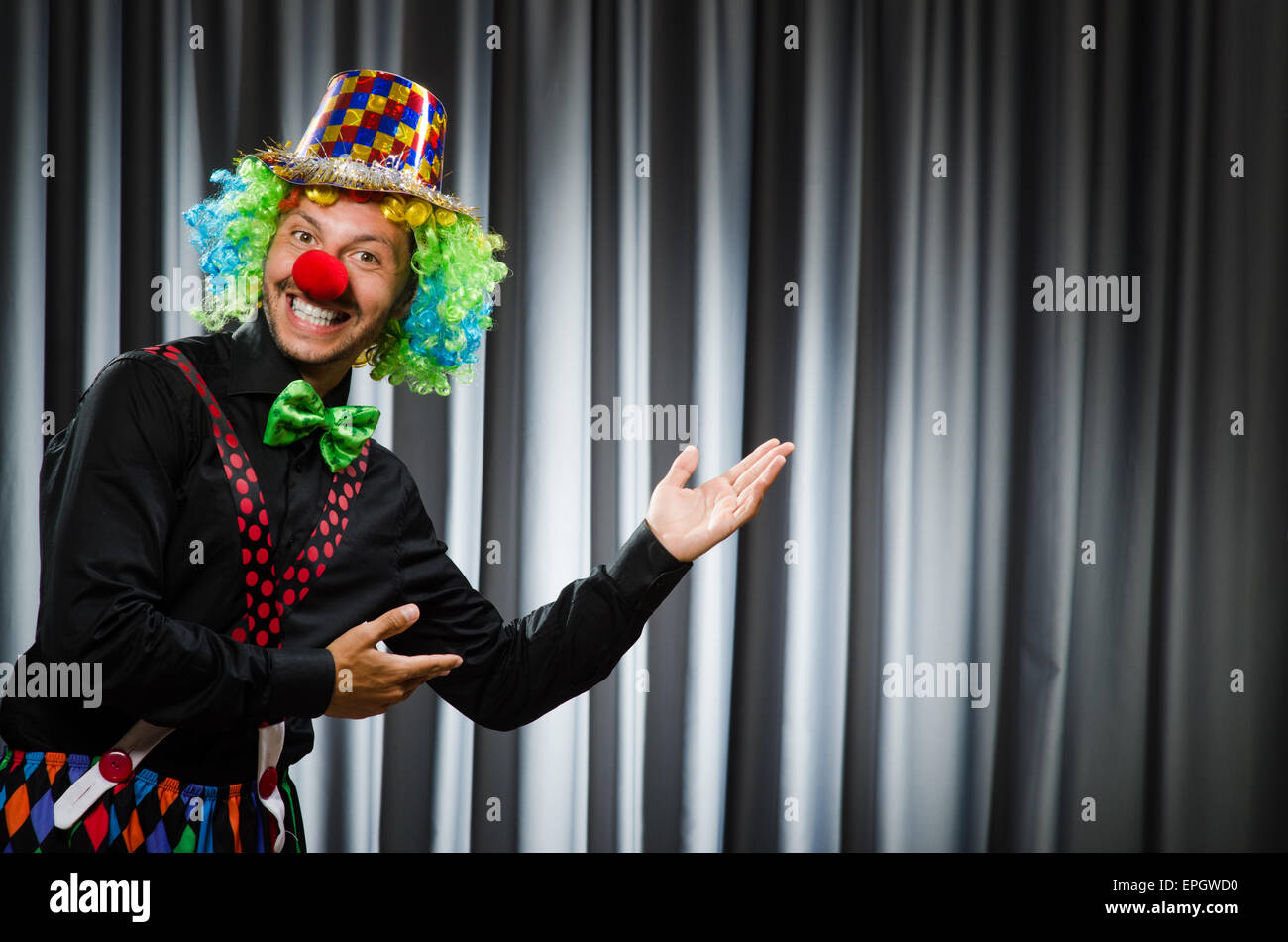 Funny clown in humorous concept against curtain Stock Photo - Alamy