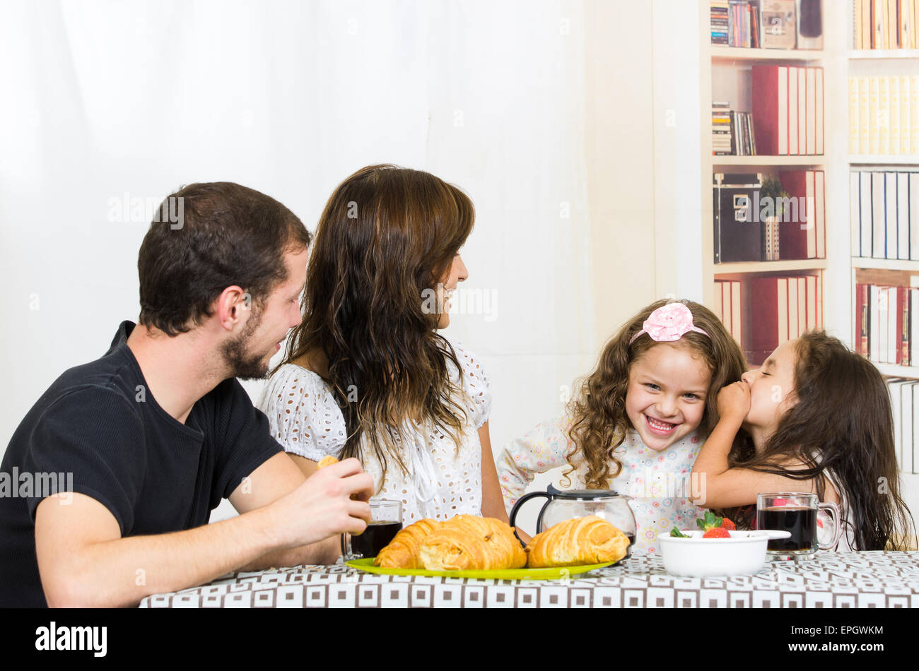 Beautiful young happy family eating meal Stock Photo - Alamy
