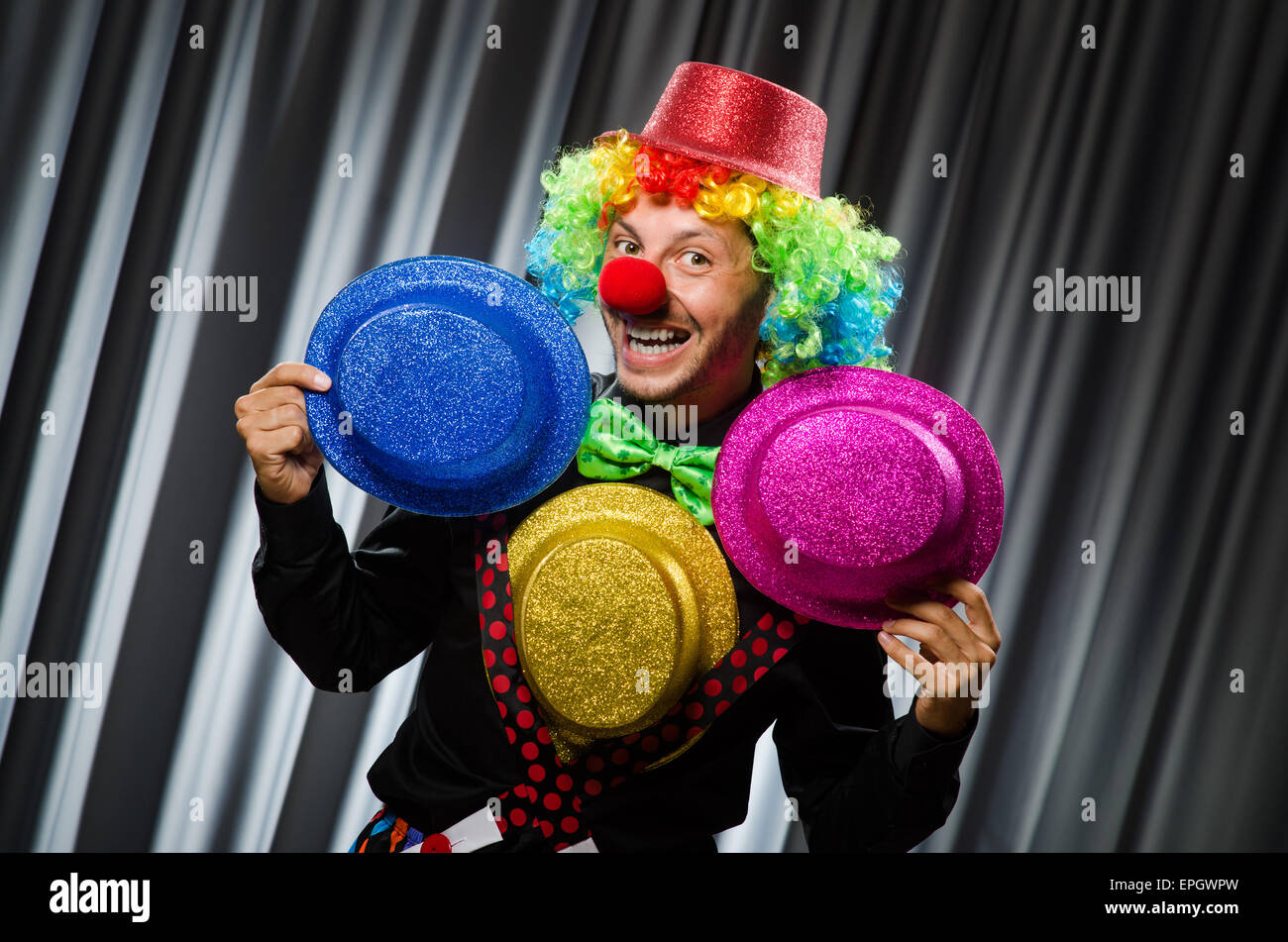Funny clown in humorous concept against curtain Stock Photo - Alamy