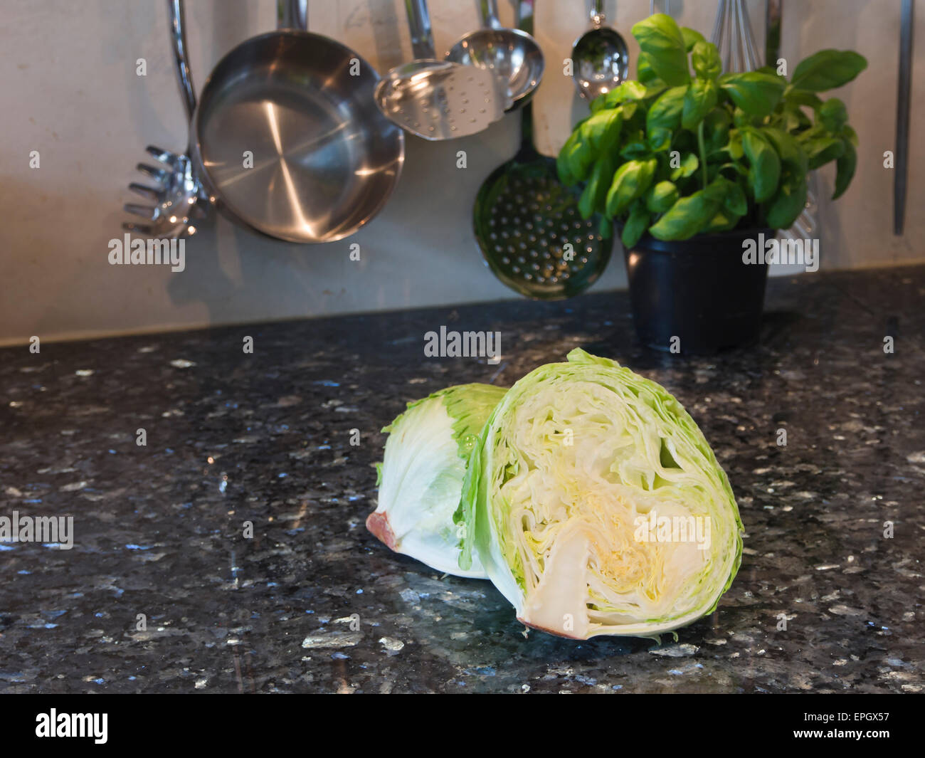 Halved crispy lettuce on a dark granite countertop, with kitchen ...