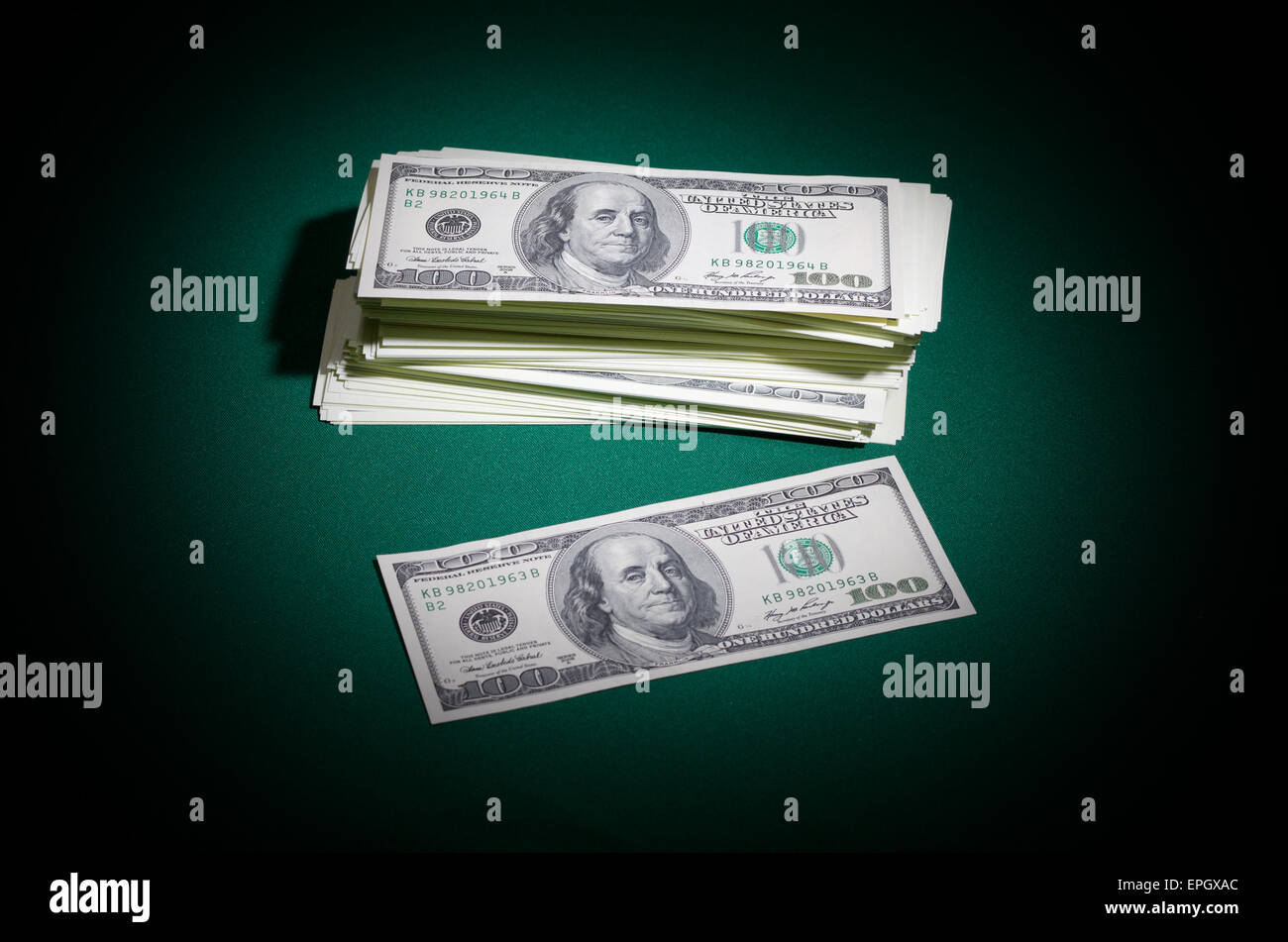 Stack of dollars on green table Stock Photo - Alamy