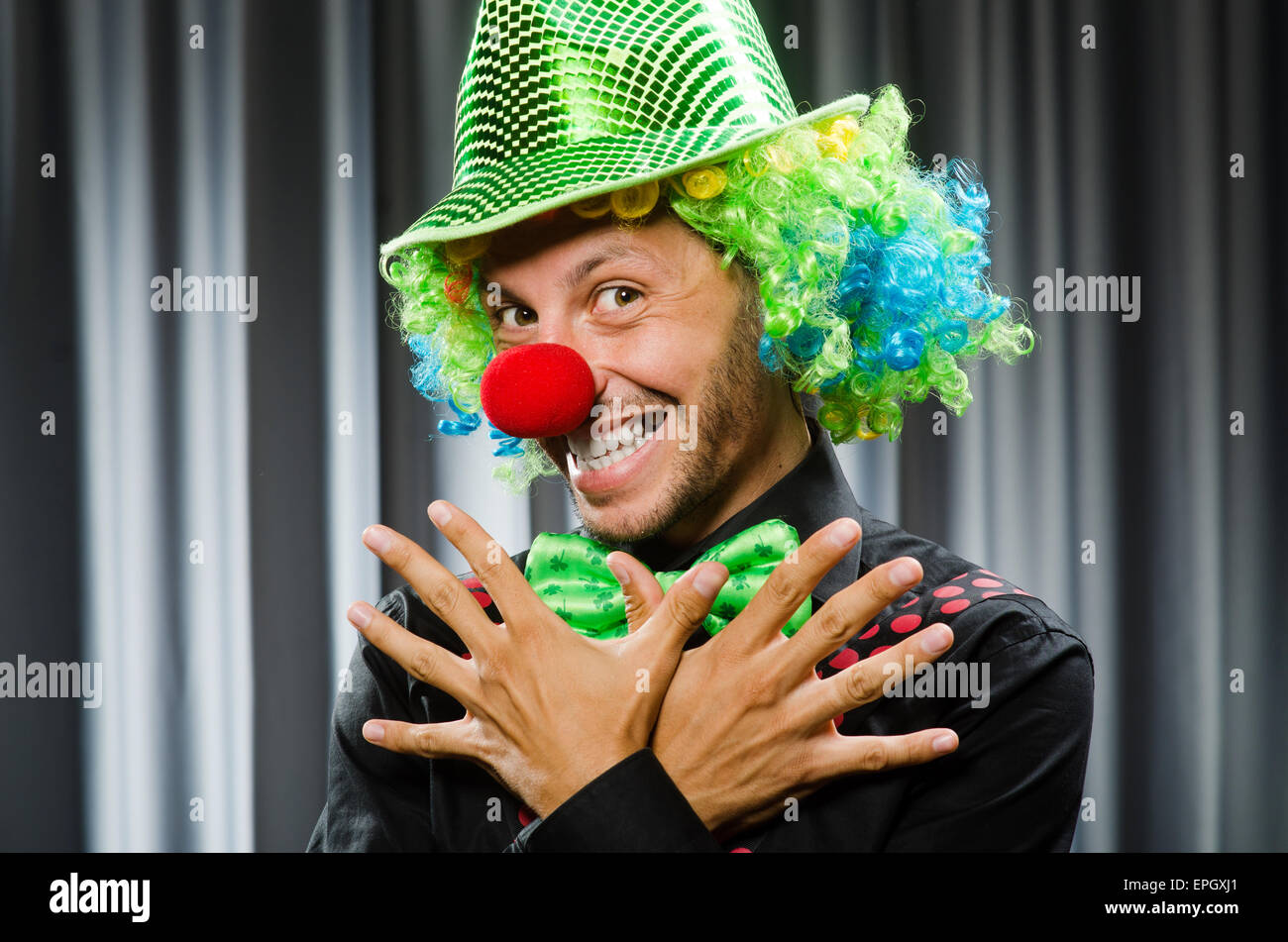 Funny clown in humorous concept against curtain Stock Photo - Alamy