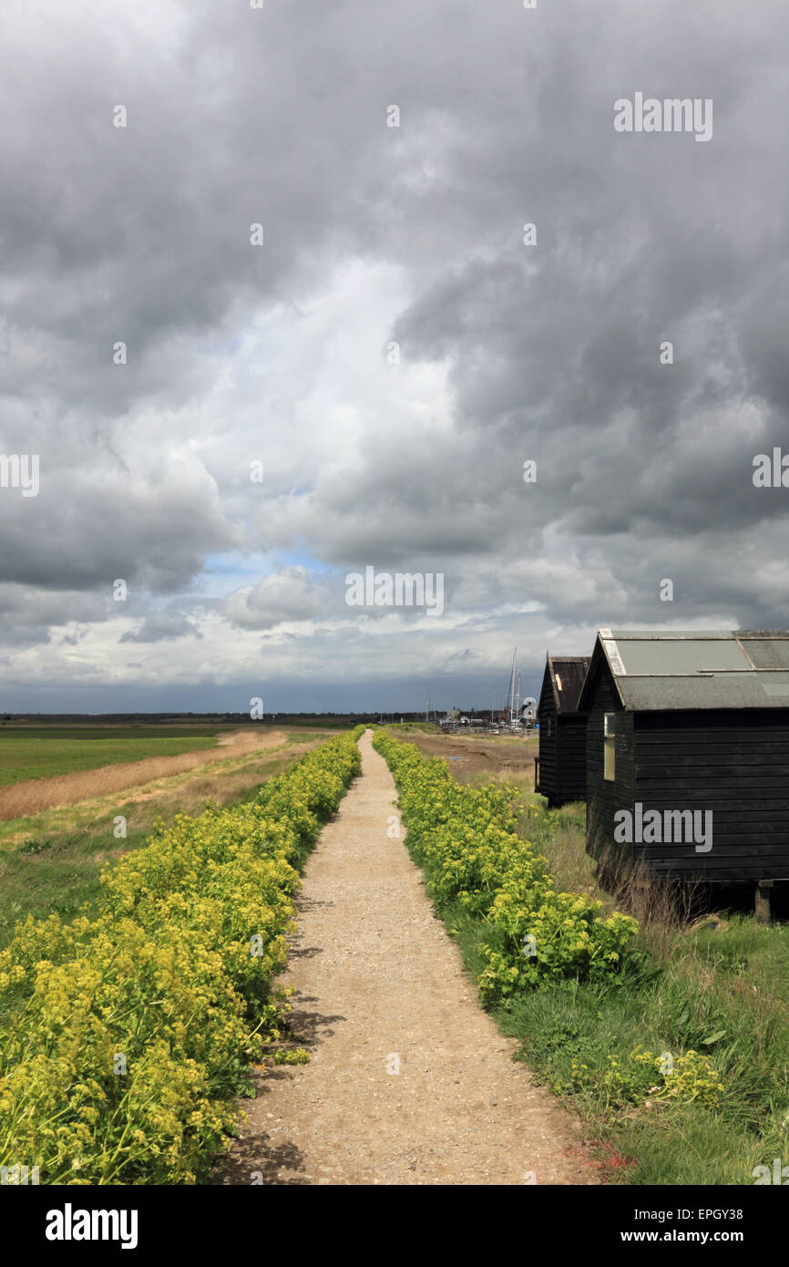 Stromy skies over the Suffolk coastal path beside the harbour at ...