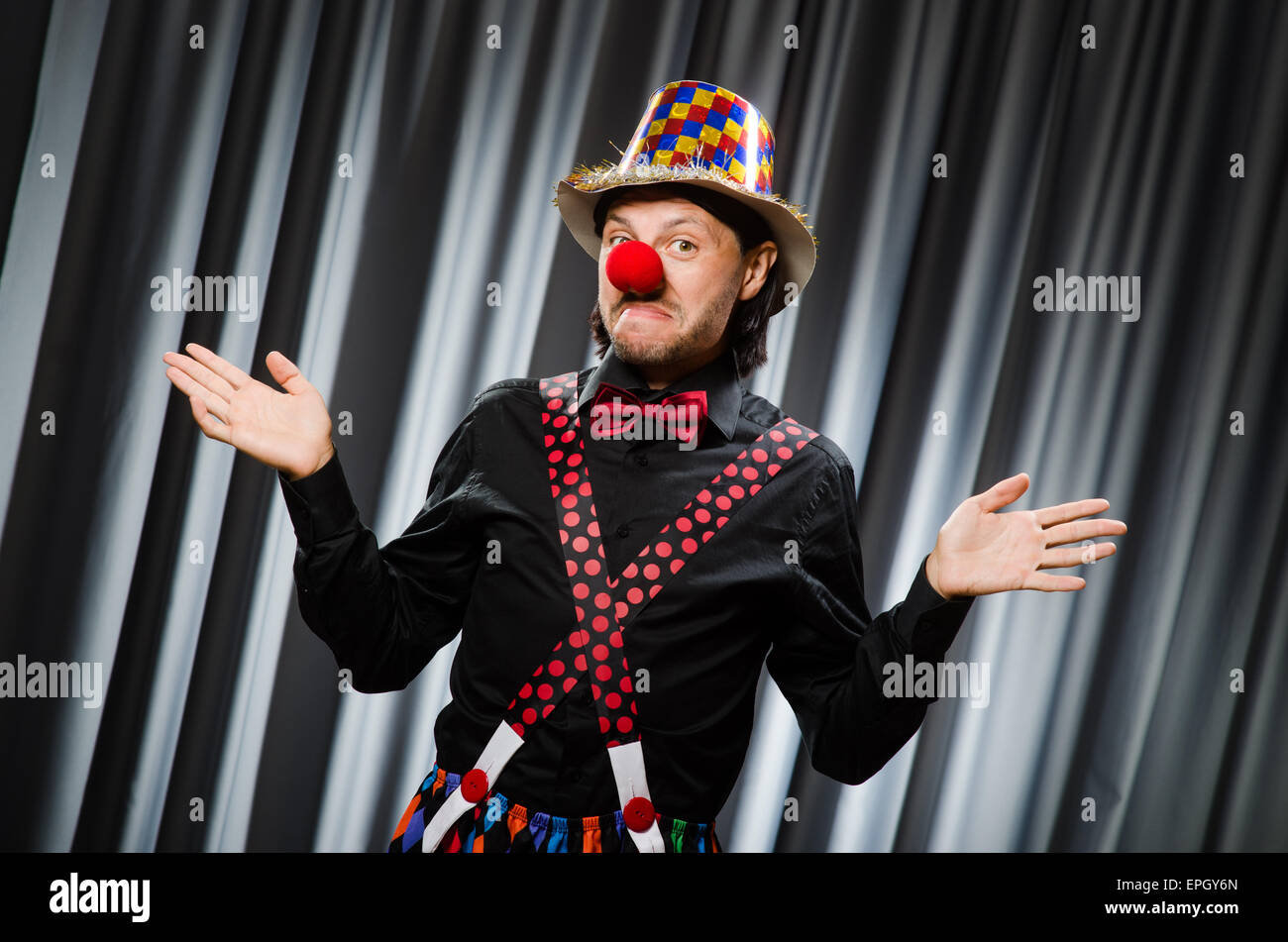 Funny clown in humorous concept against curtain Stock Photo - Alamy