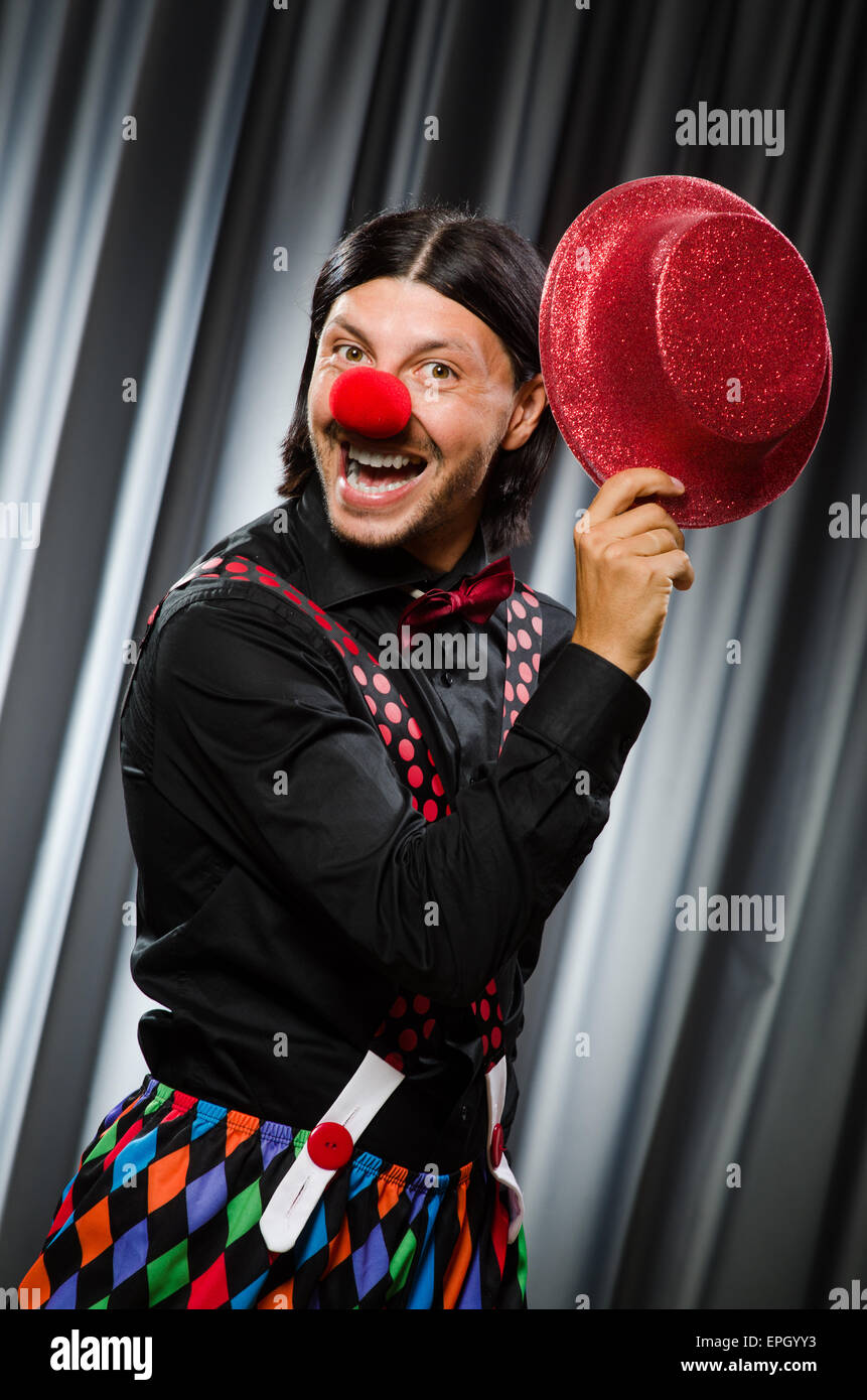 Funny clown in humorous concept against curtain Stock Photo - Alamy