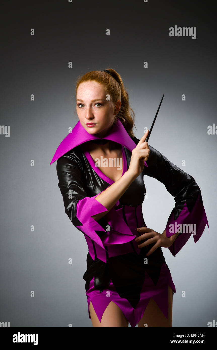 Female magician doing tricks on grey background Stock Photo - Alamy