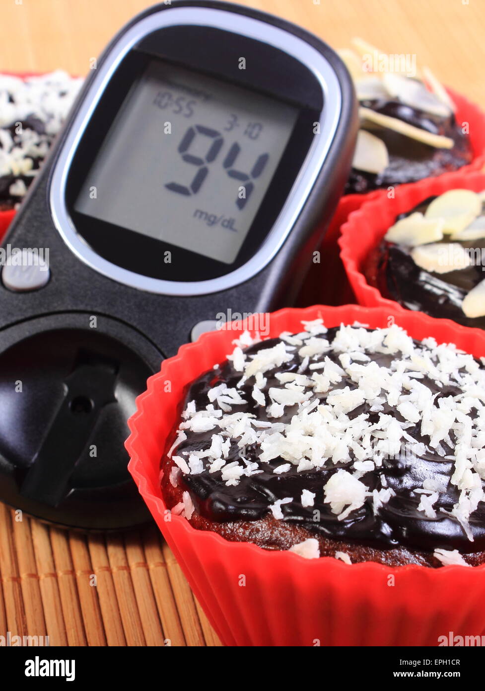 Glucometer and homemade delicious fresh baked chocolate muffins in red ...