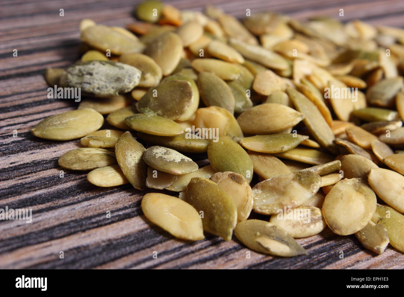 Heap of pumpkin seeds lying on wooden background, concept for healthy ...