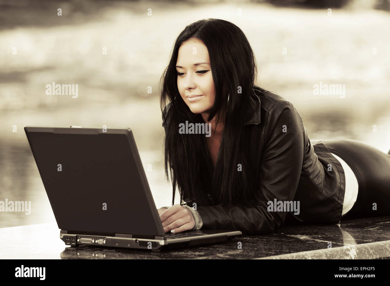 Young woman using laptop outdoor Stock Photo - Alamy