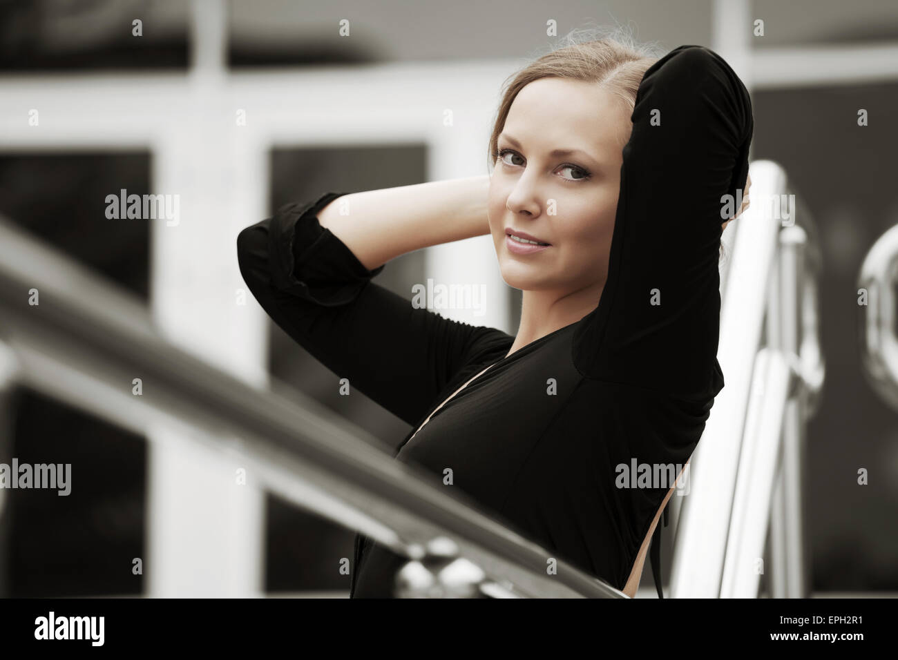 Beautiful young woman leaning on the handrail Stock Photo - Alamy