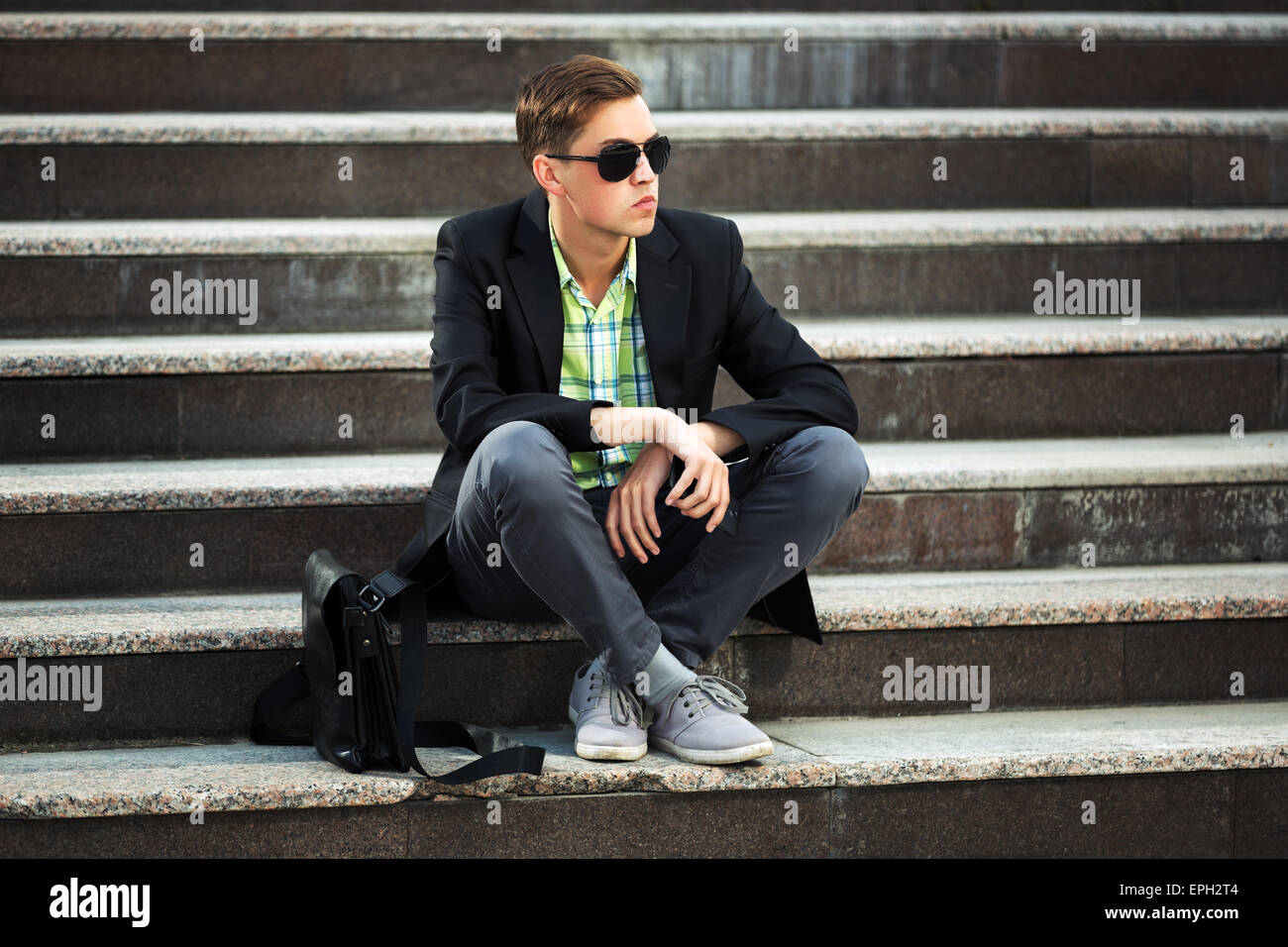 Young fashion man sitting on the steps Stock Photo - Alamy