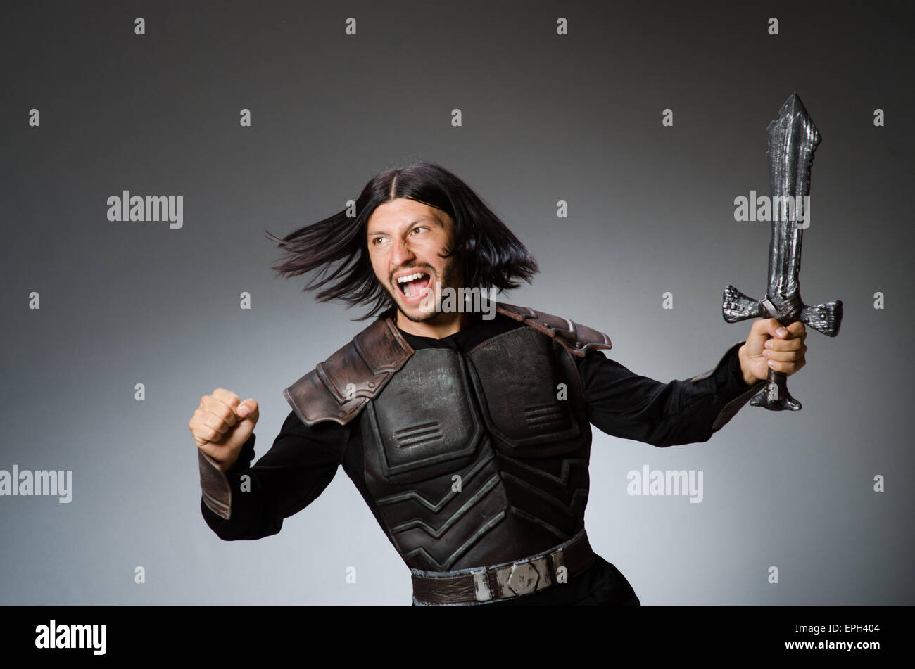 Angry knight with sword against dark background Stock Photo - Alamy