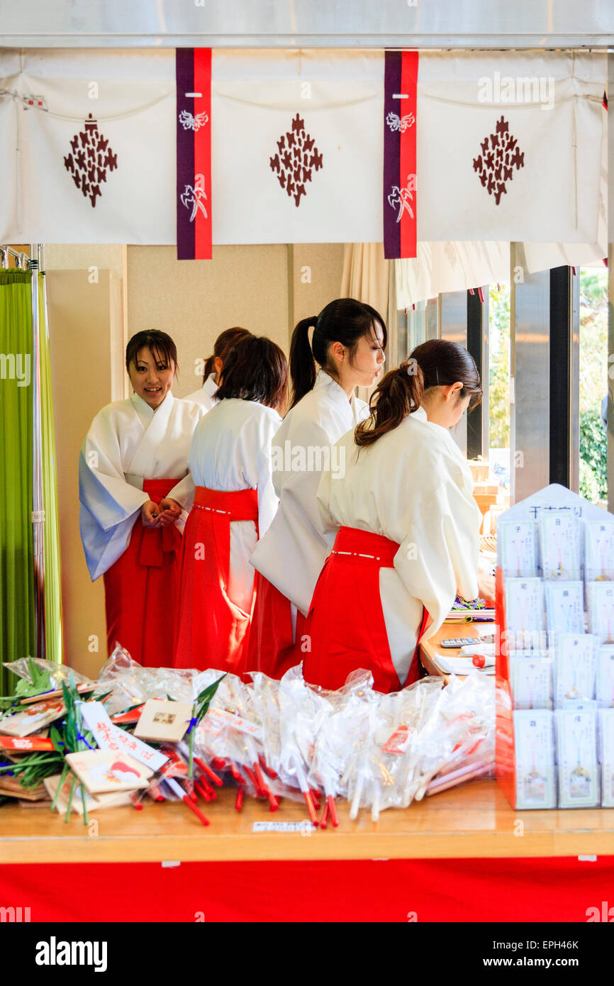 Line of 5 miko, shrine maidens, in traditional red and white costume ...