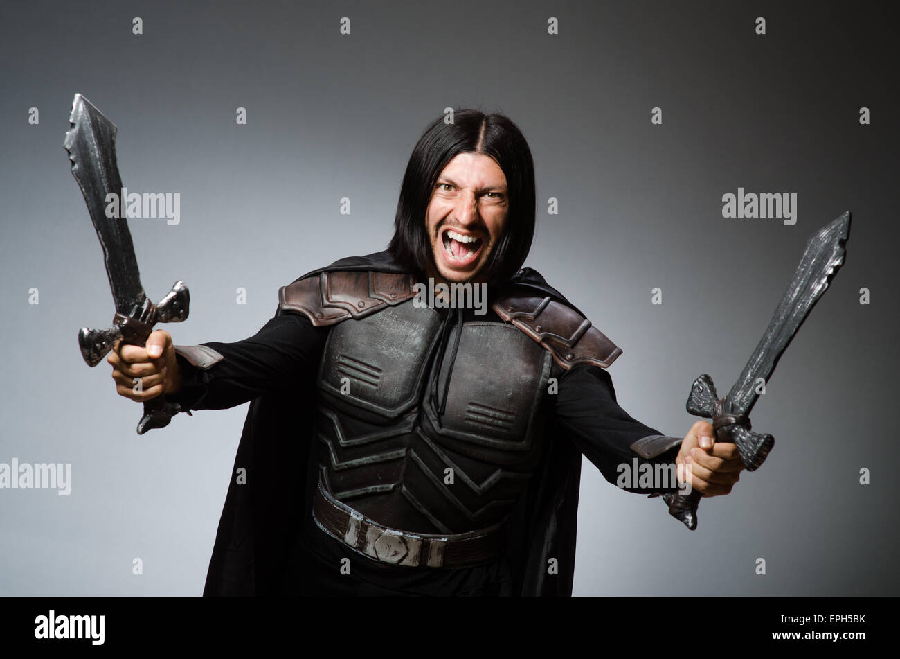 Angry knight with sword against dark background Stock Photo - Alamy