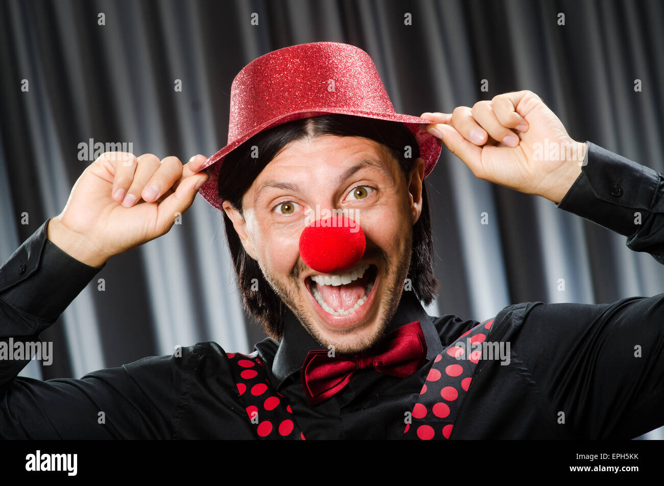 Funny clown in humorous concept against curtain Stock Photo - Alamy