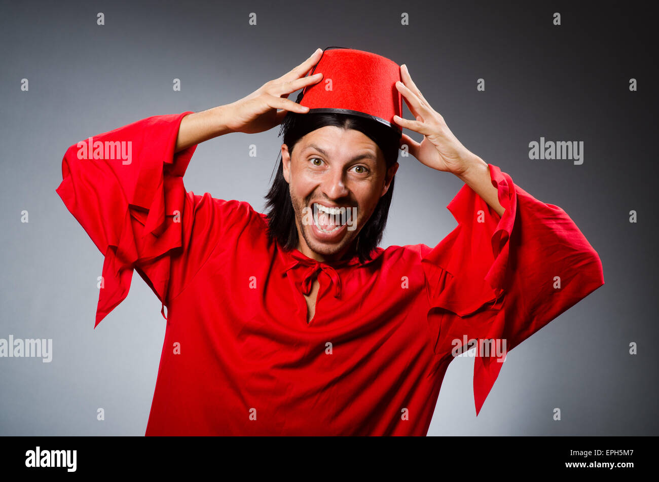 Funny man in red dress wearing fez hat Stock Photo - Alamy