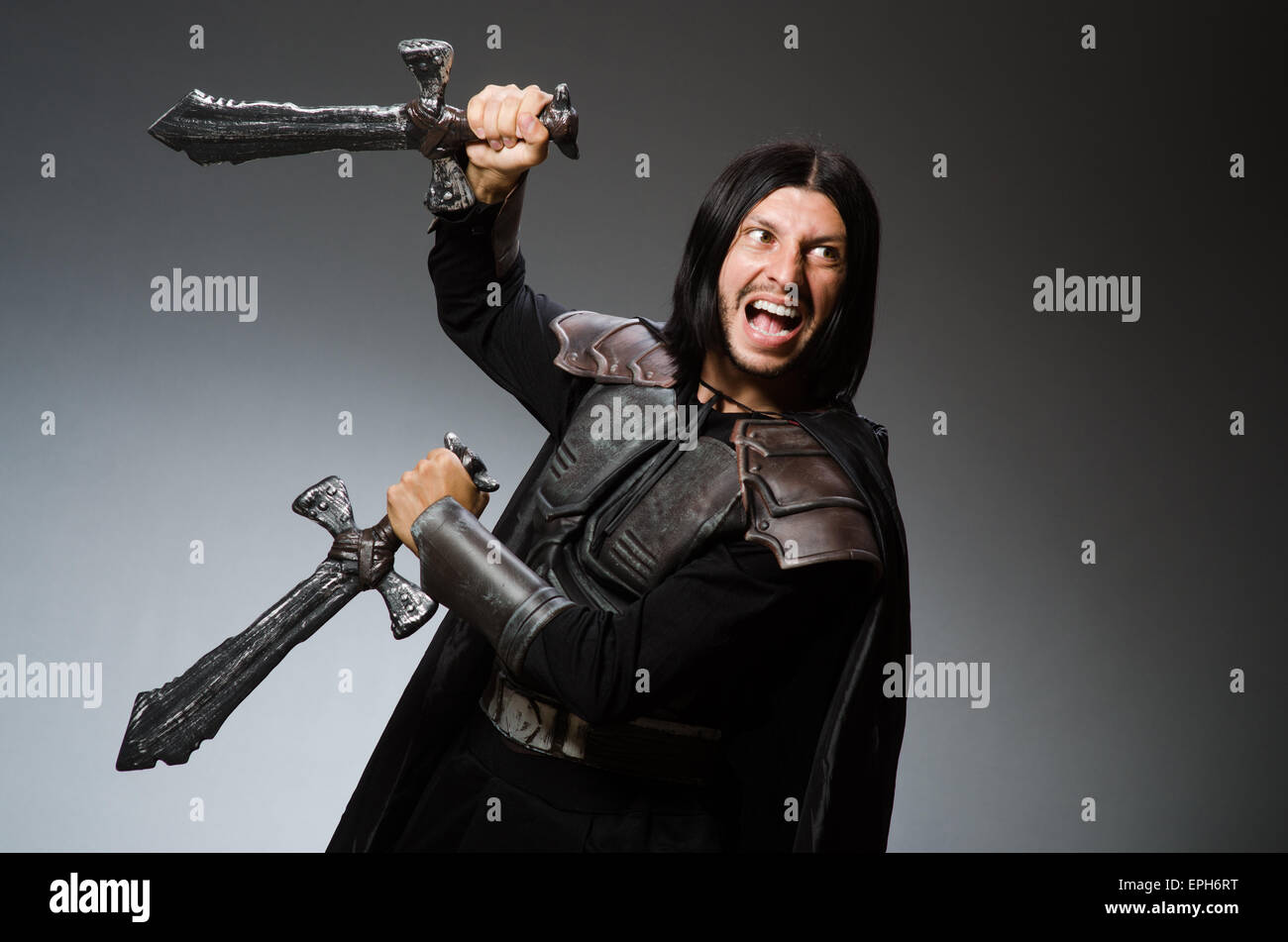 Angry knight with sword against dark background Stock Photo - Alamy