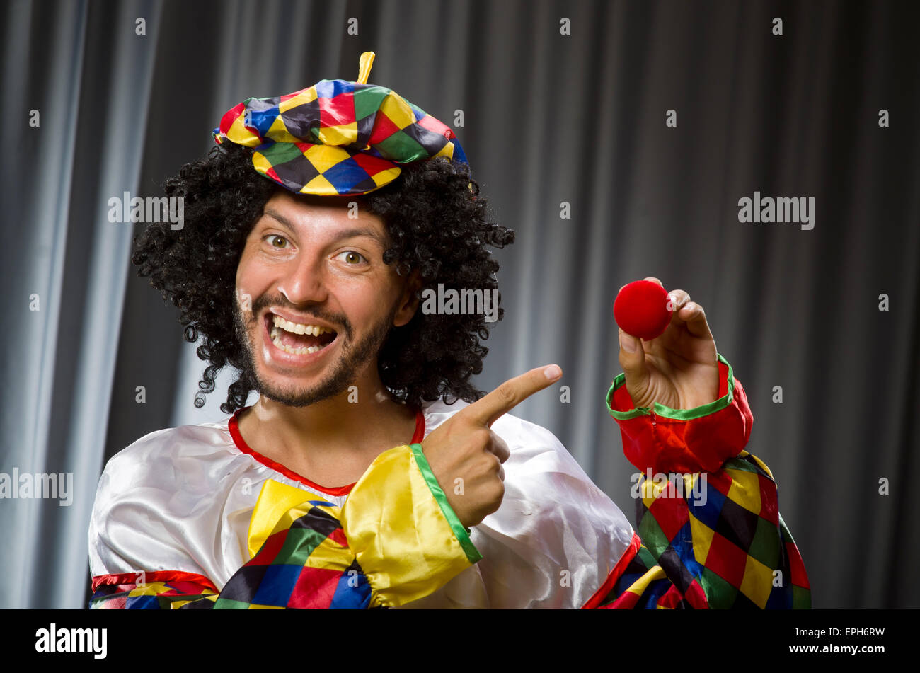 Funny clown in humorous concept against curtain Stock Photo - Alamy