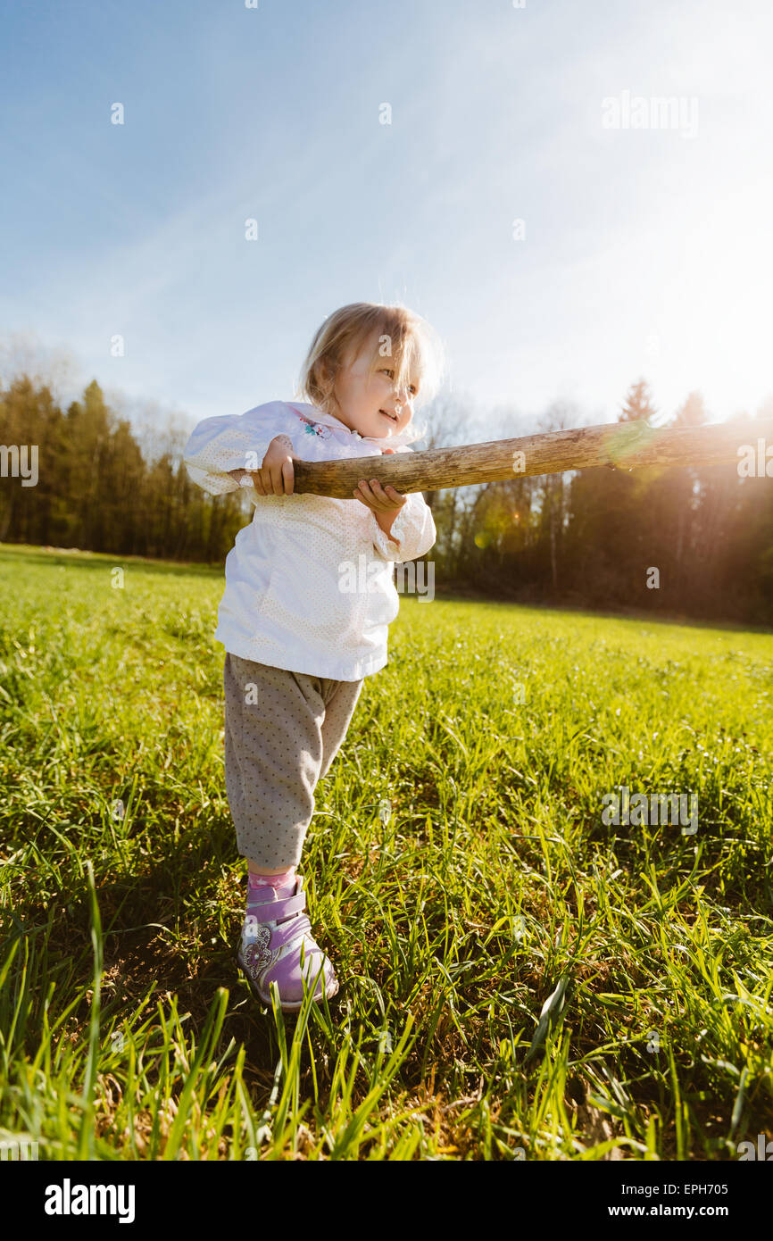 Little girl with a stick Stock Photo - Alamy