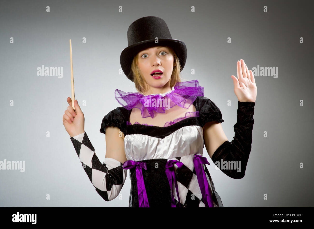 Woman magician doing her tricks with wand Stock Photo - Alamy