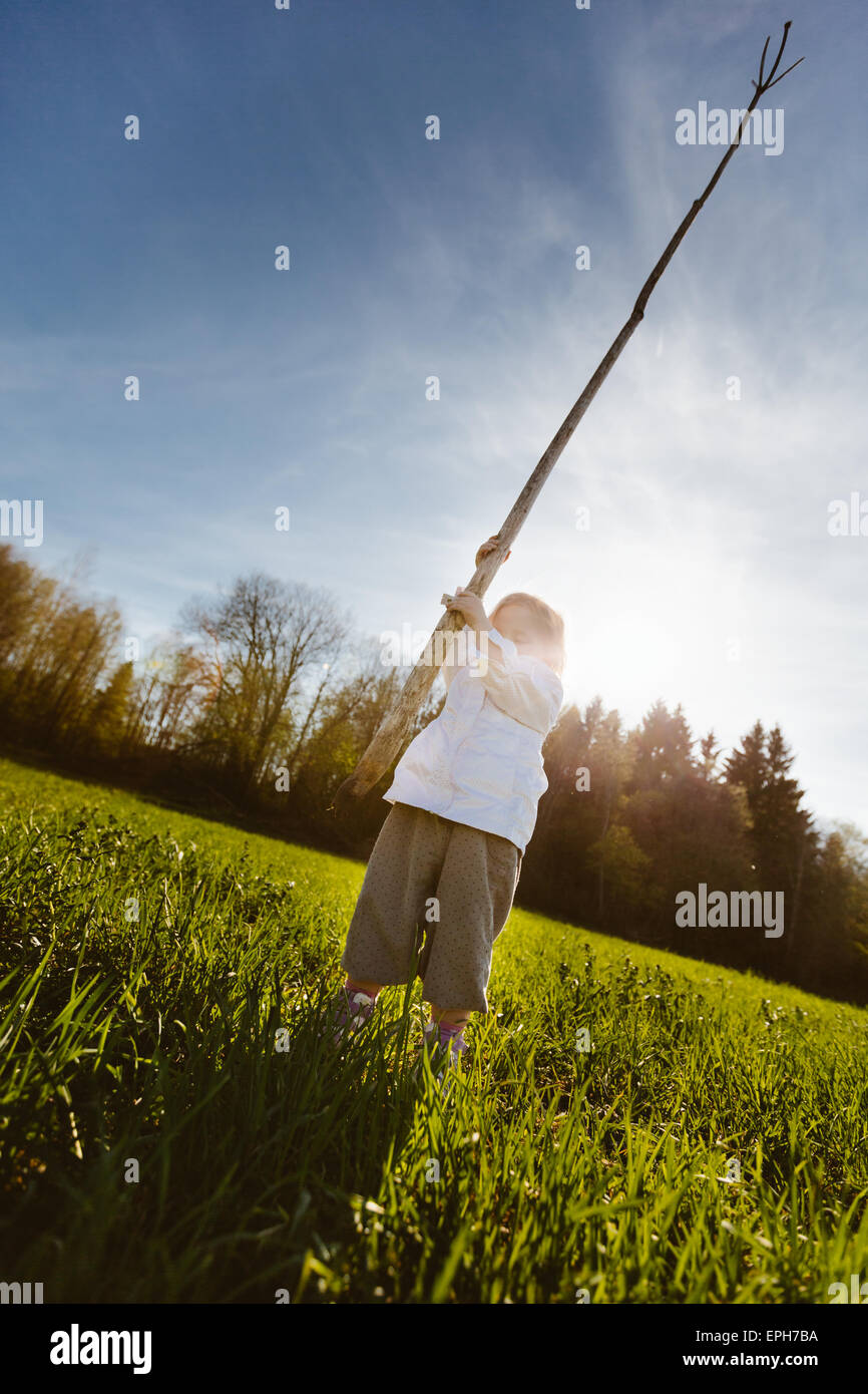 Little girl with a stick Stock Photo - Alamy